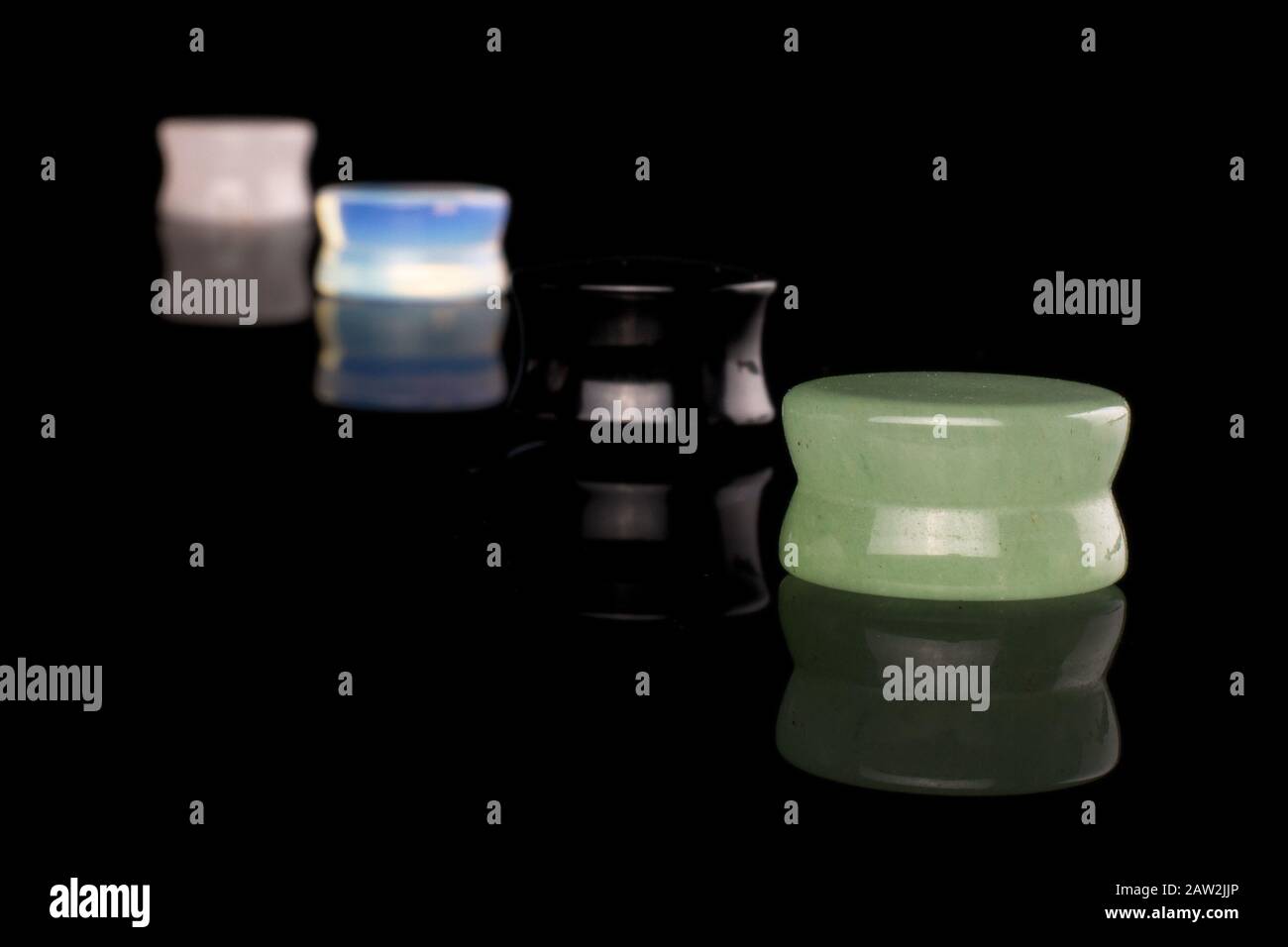 Group of four whole plug diagonal isolated on black glass Stock Photo ...