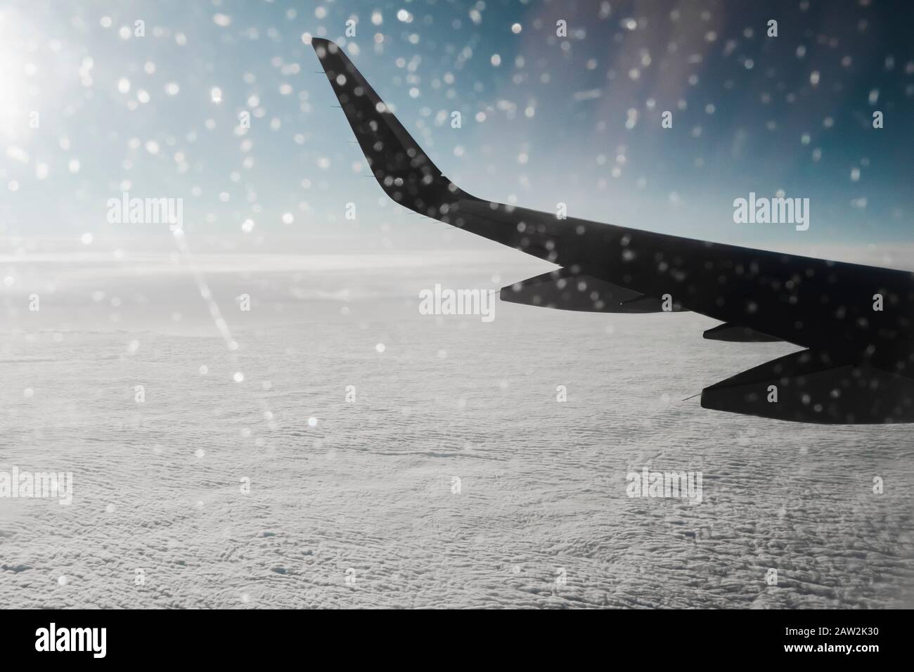 View of the morning winter sky through a frozen window of an airplane ...