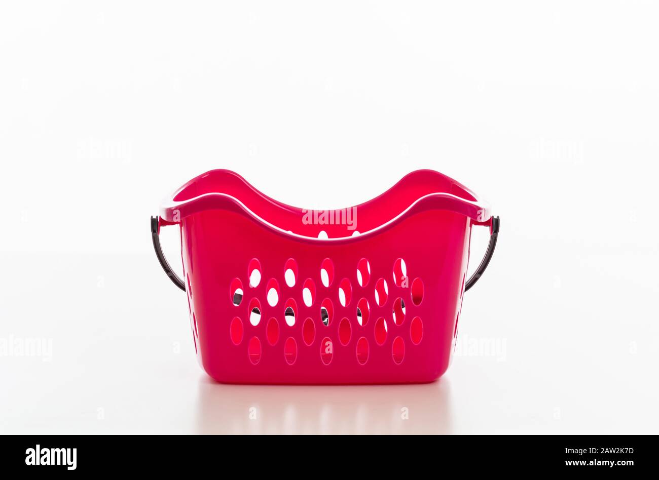 Laundry basket, plastic red color isolated against white background ...