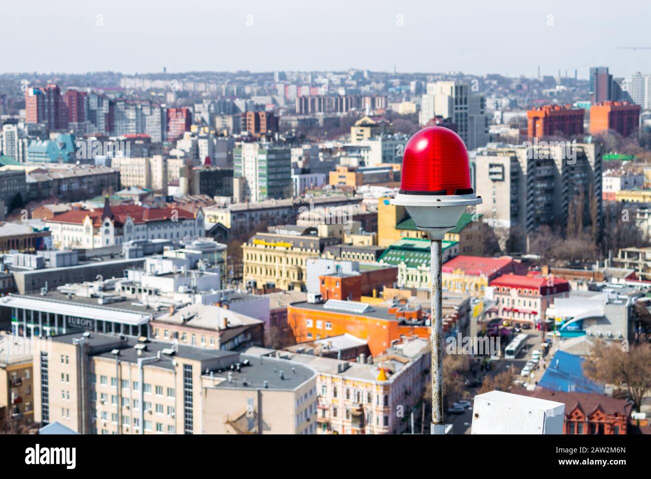 A red alarm lamp is located on the roof of a high-rise building ...