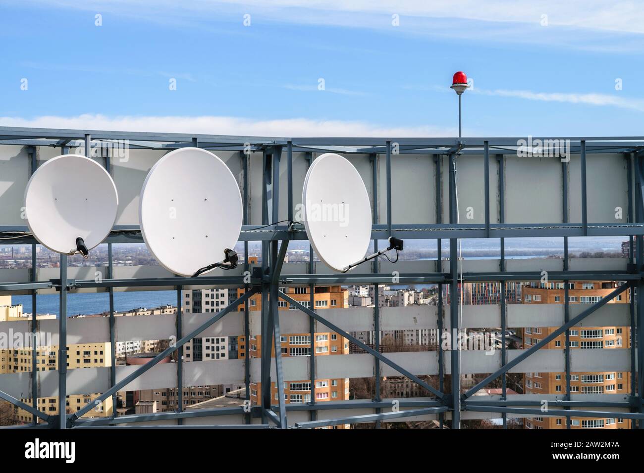 Three satellite antennas are installed on the roof of the building ...