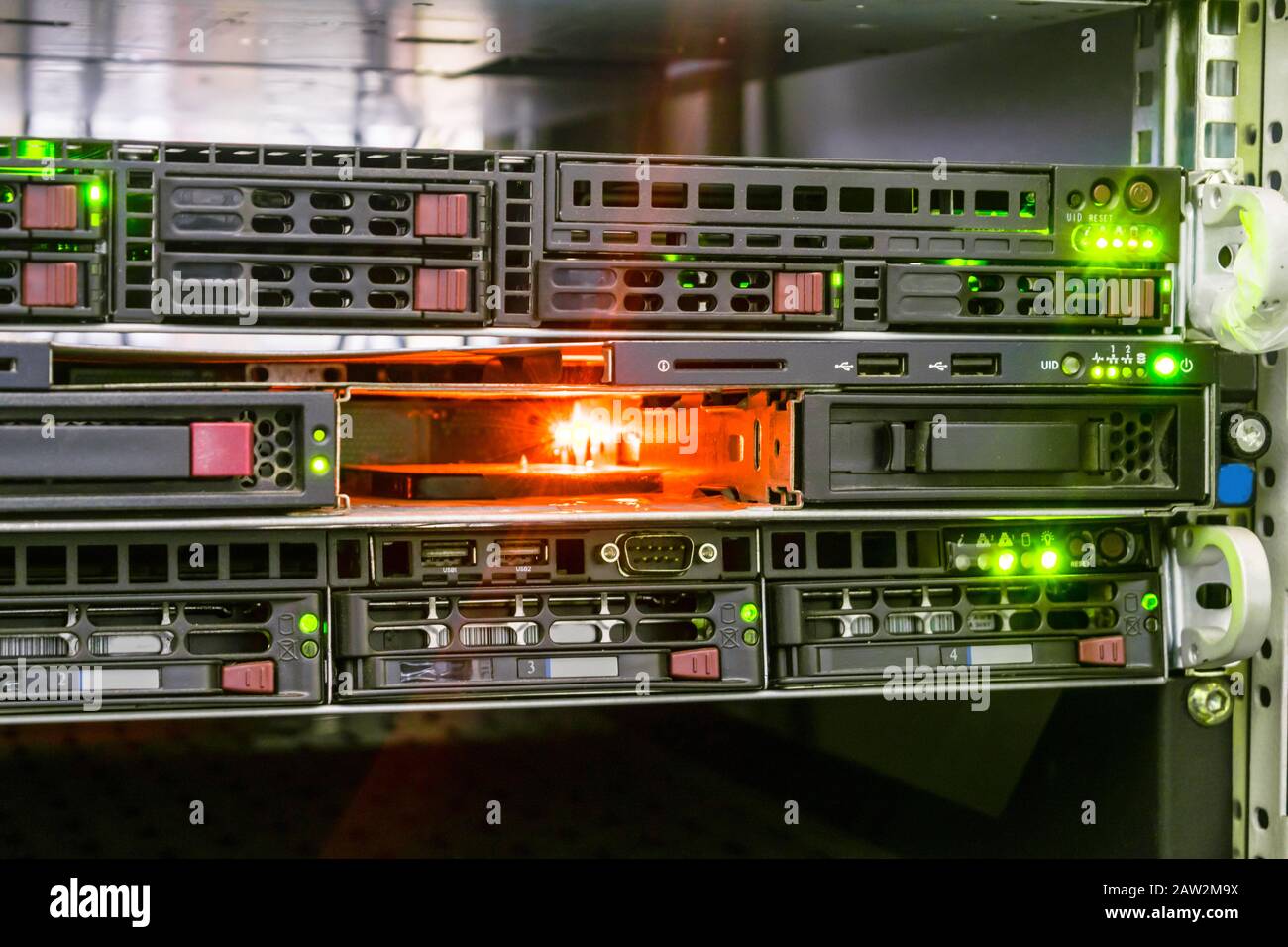 A server with multiple hard drives works in a data center rack. A place ...