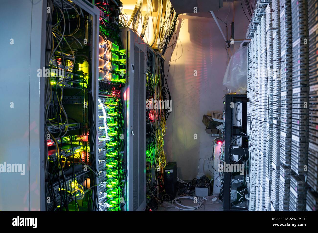 Many wires and computer equipment work in a dark server room. The ...