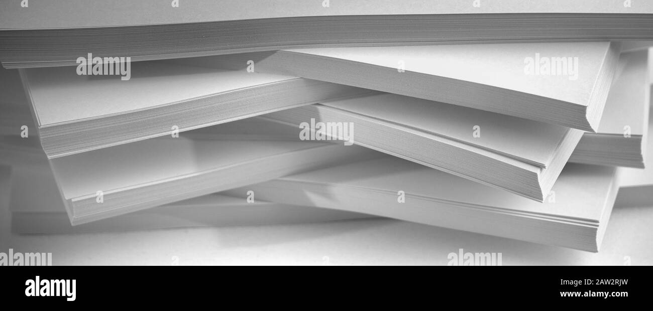 Several stacks of white paper on a white background Stock Photo - Alamy