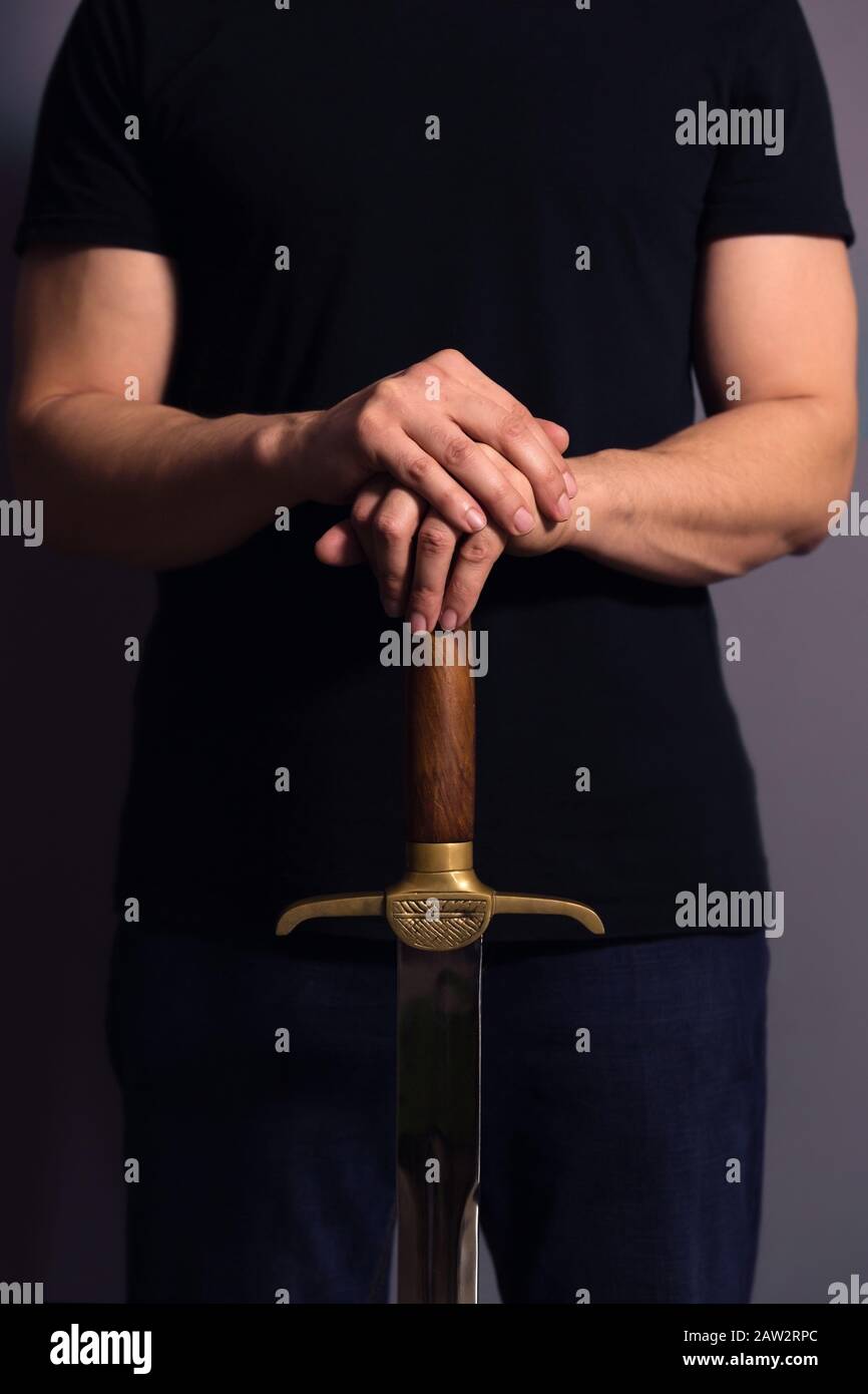 Casually dressed strong young guy standing ready with his sword Stock ...