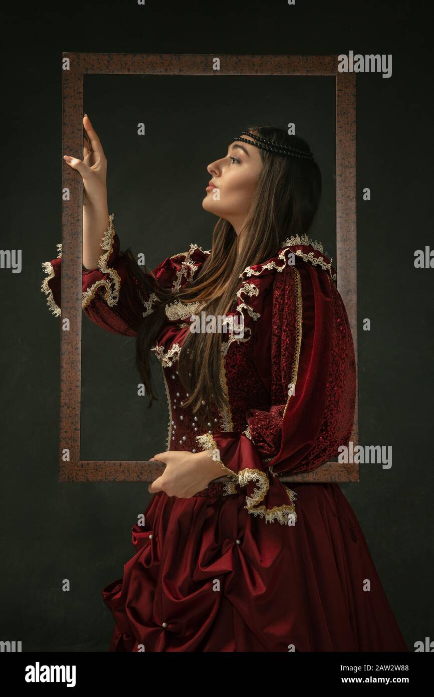 Proud. Portrait of medieval young woman in red vintage clothing ...