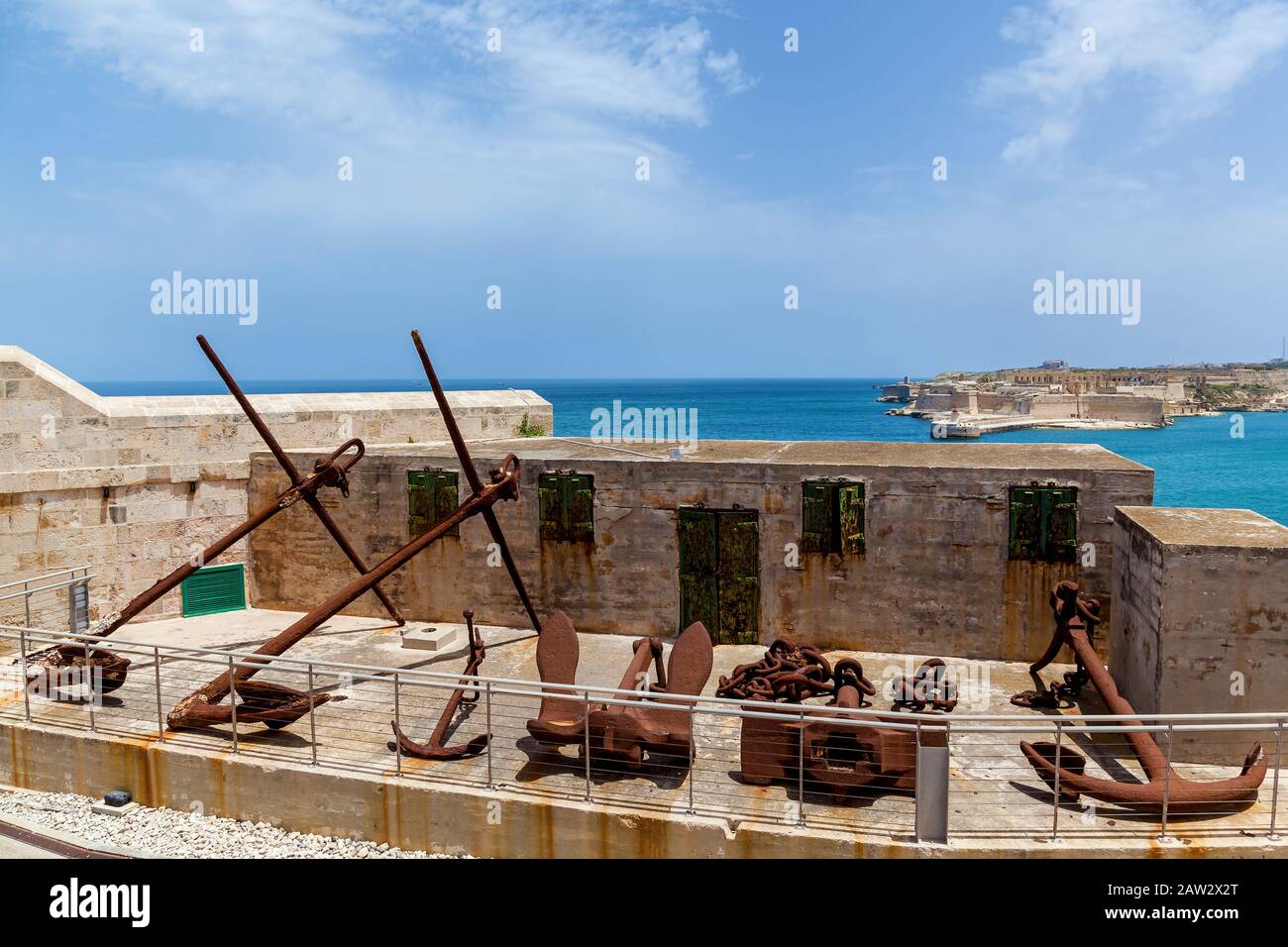 Different types of old and rusty anchors laying near ashore on the ...