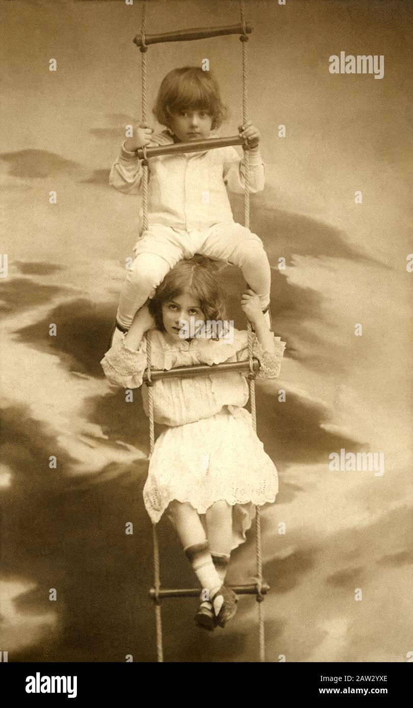 1905 ca , FRANCE : Two children play in the sky on a rope ladder ...