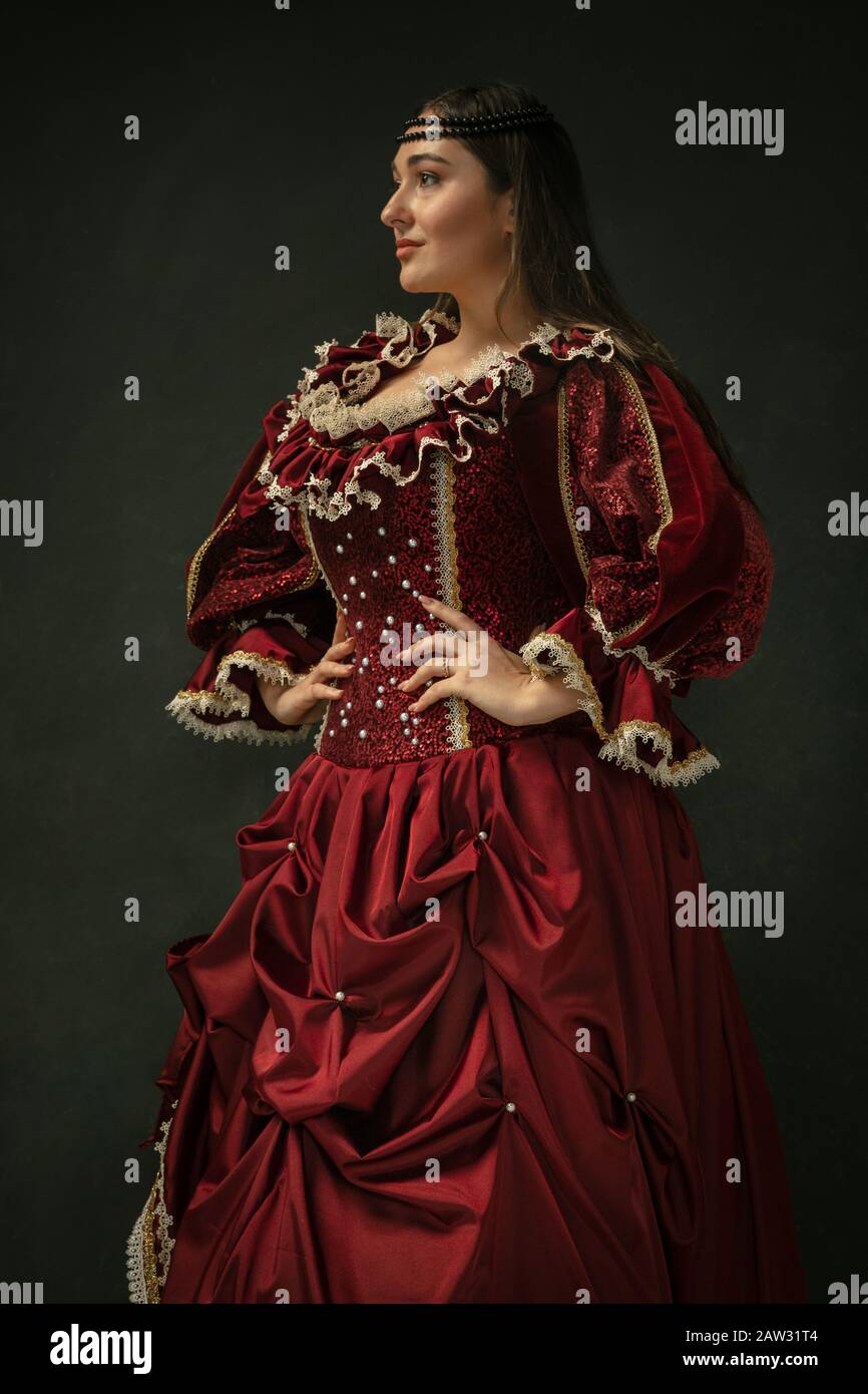 Posing as royal. Portrait of medieval young woman in red vintage ...
