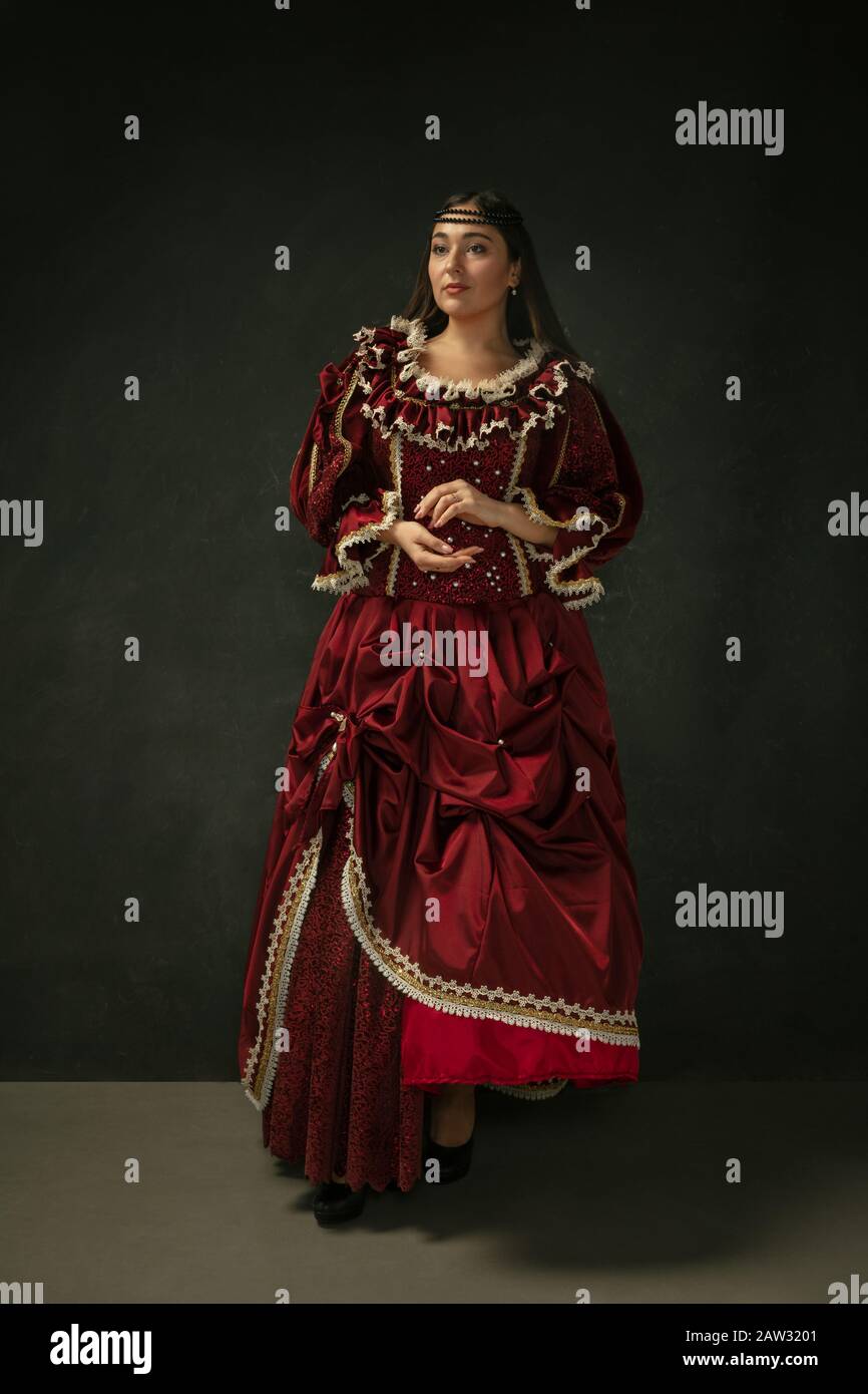 Posing as royal. Portrait of medieval young woman in red vintage ...