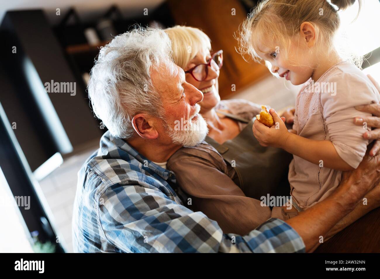 Happy grandparents playing with their little cute granddaughter Stock ...