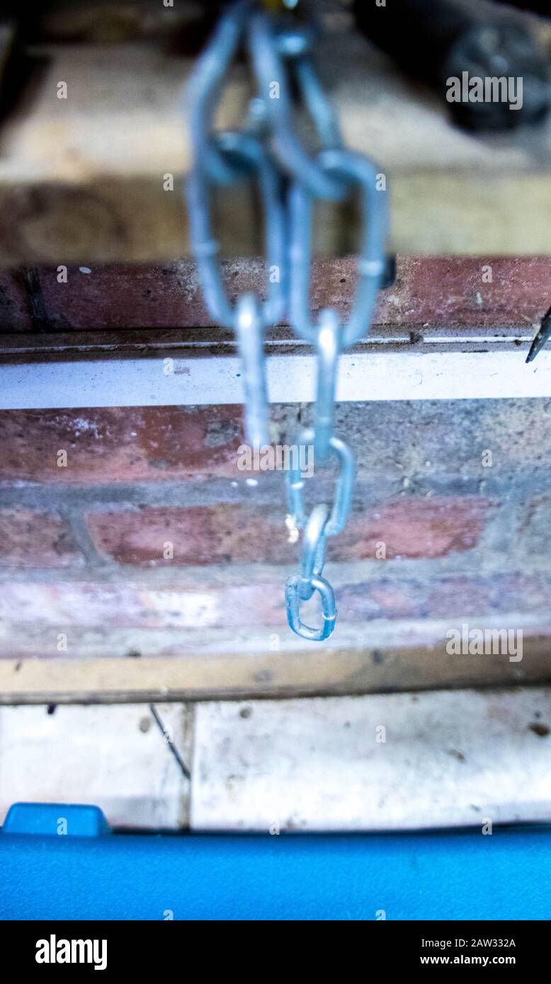 Several heavy duty silver chains hanging from a shed roof Stock Photo ...