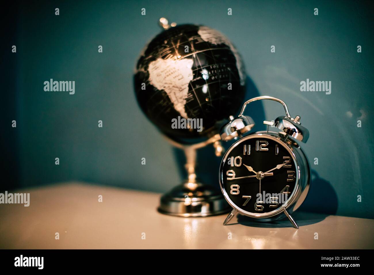 Globe and alarm clock on shelf Stock Photo - Alamy