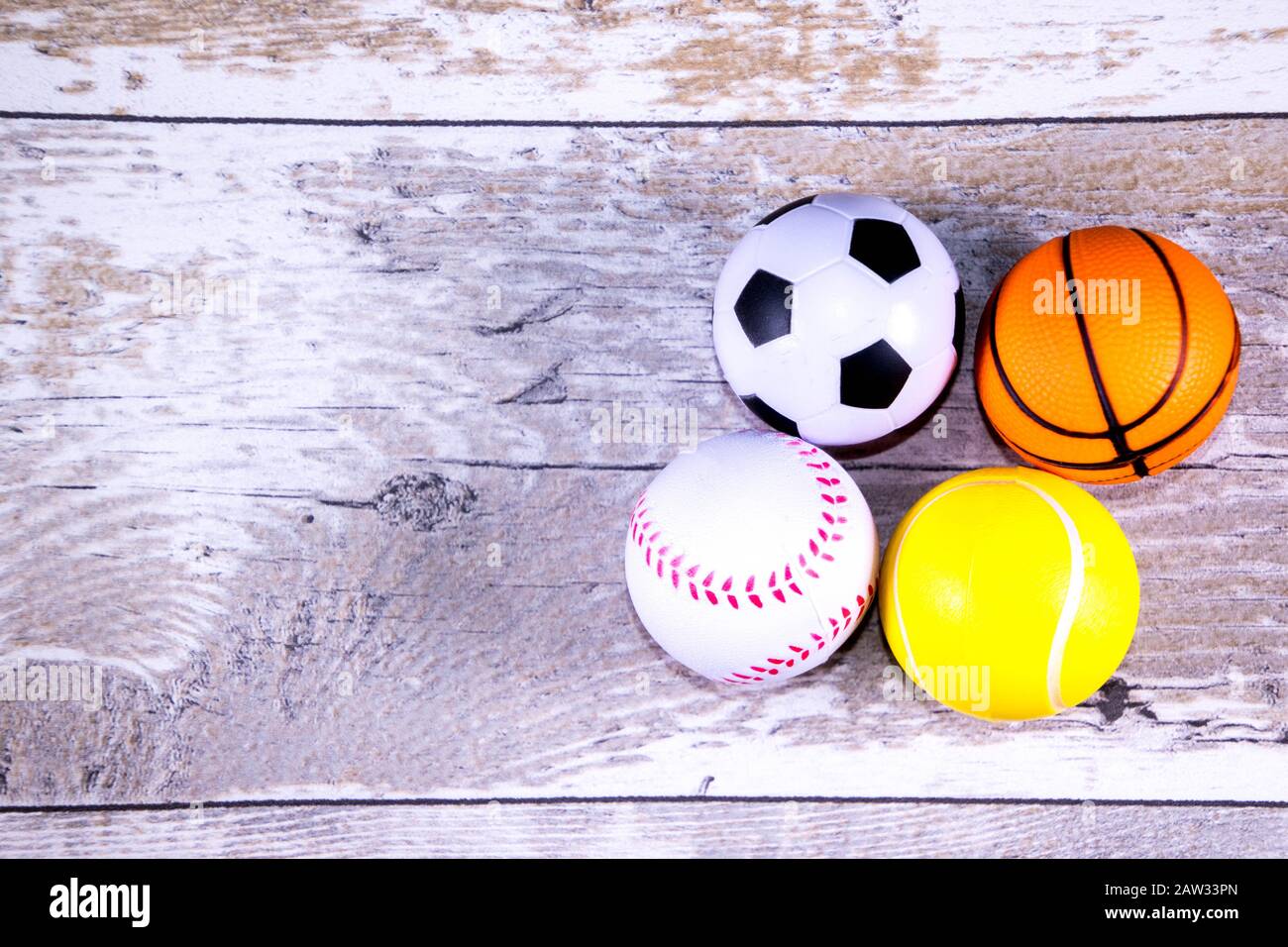 A closeup image of a stack of sports balls against a reflective blue ...
