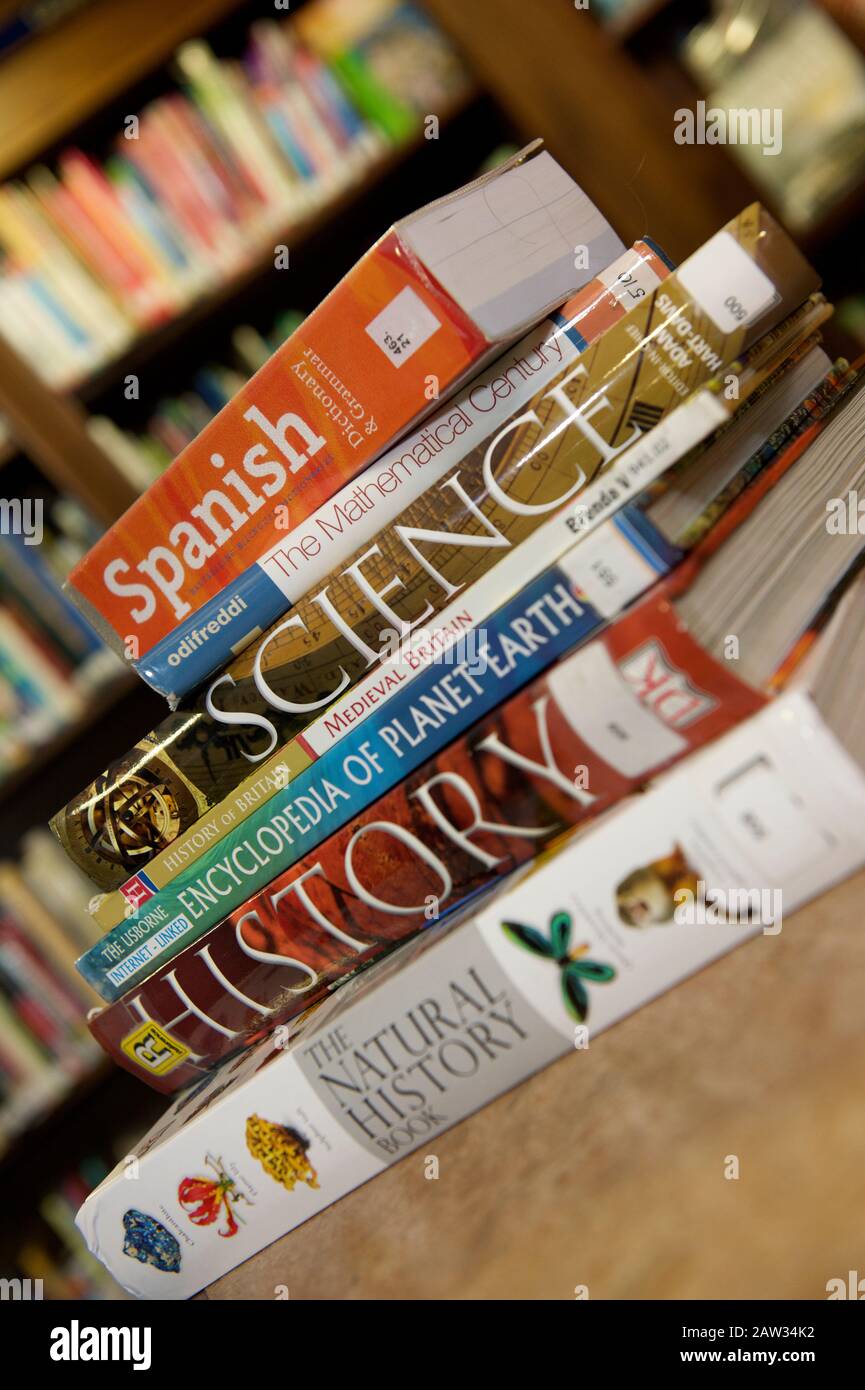 A pile of educational school books on a wooden table in a library Stock ...