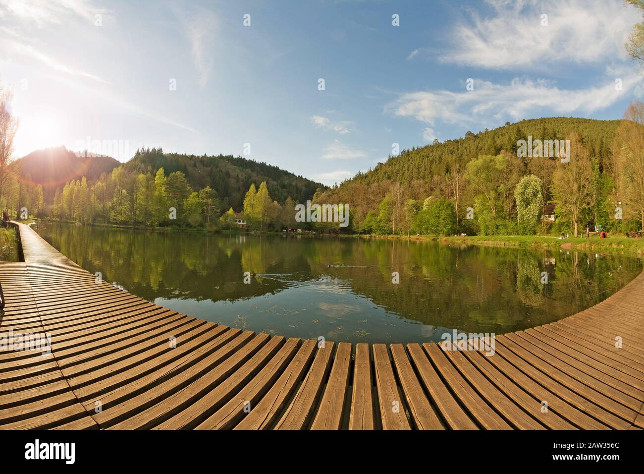 idyllic pond with wooden footbridge on a sunny day, sunset Stock Photo ...