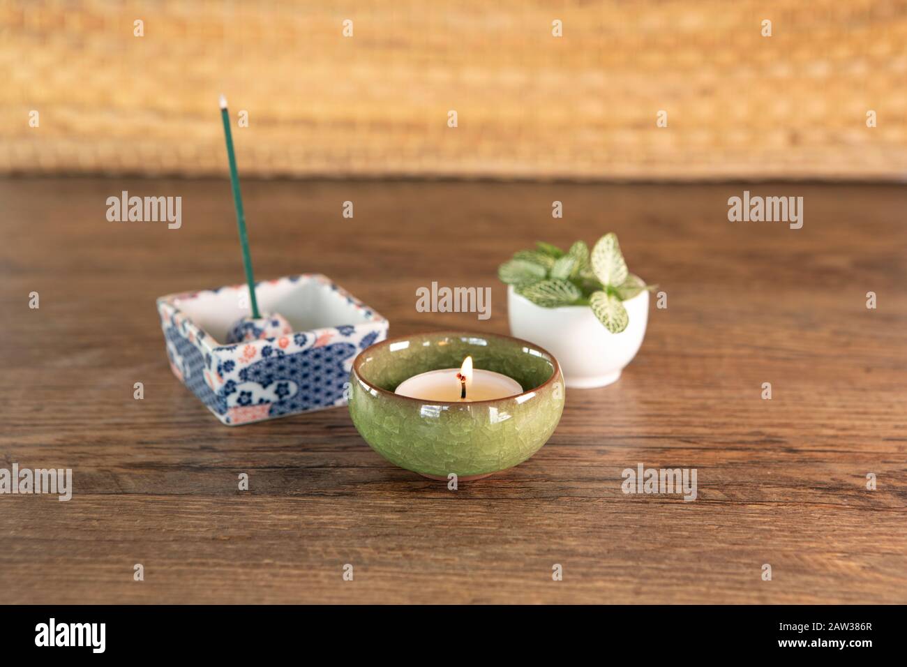 Smoking and smelling joss stick, candle with flame. Wooden background ...