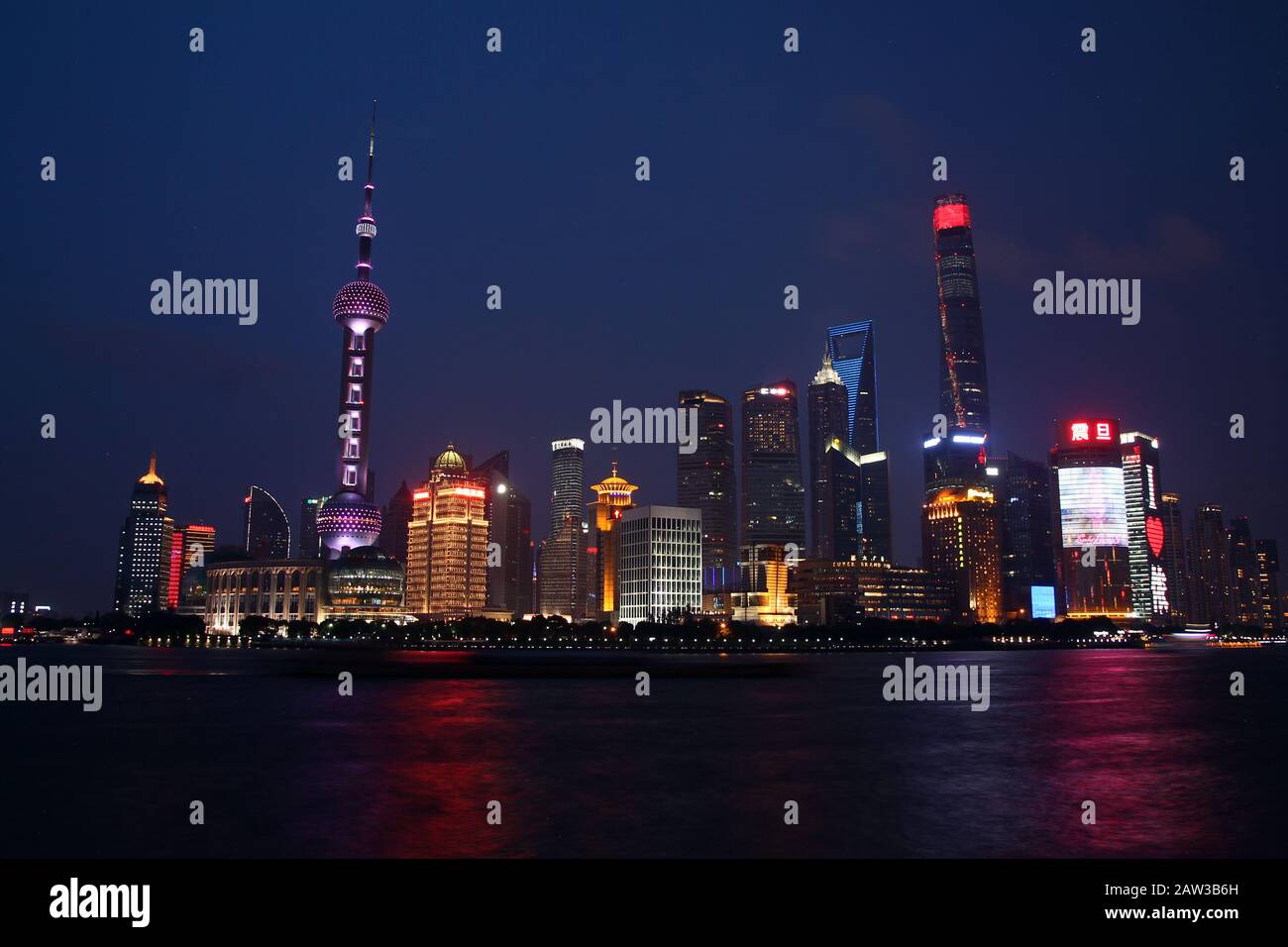 Shanghai lights and skyline on dusk from the other side of the river ...