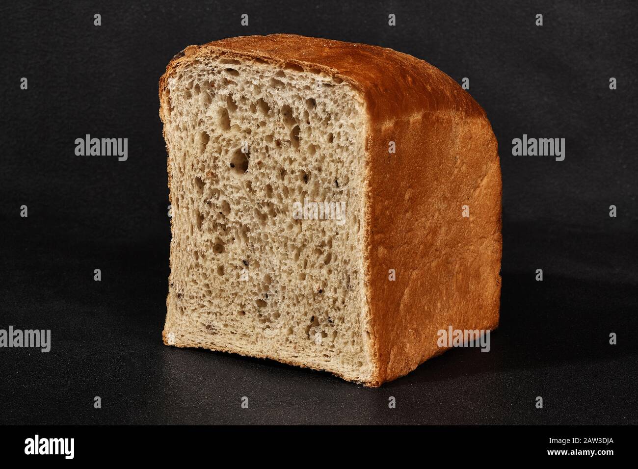 Half a loaf of fresh, delicious baked gray bread against black ...