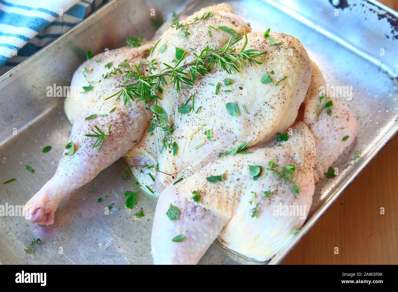 Raw chicken with seasoning and herbs ready to roast Stock Photo - Alamy