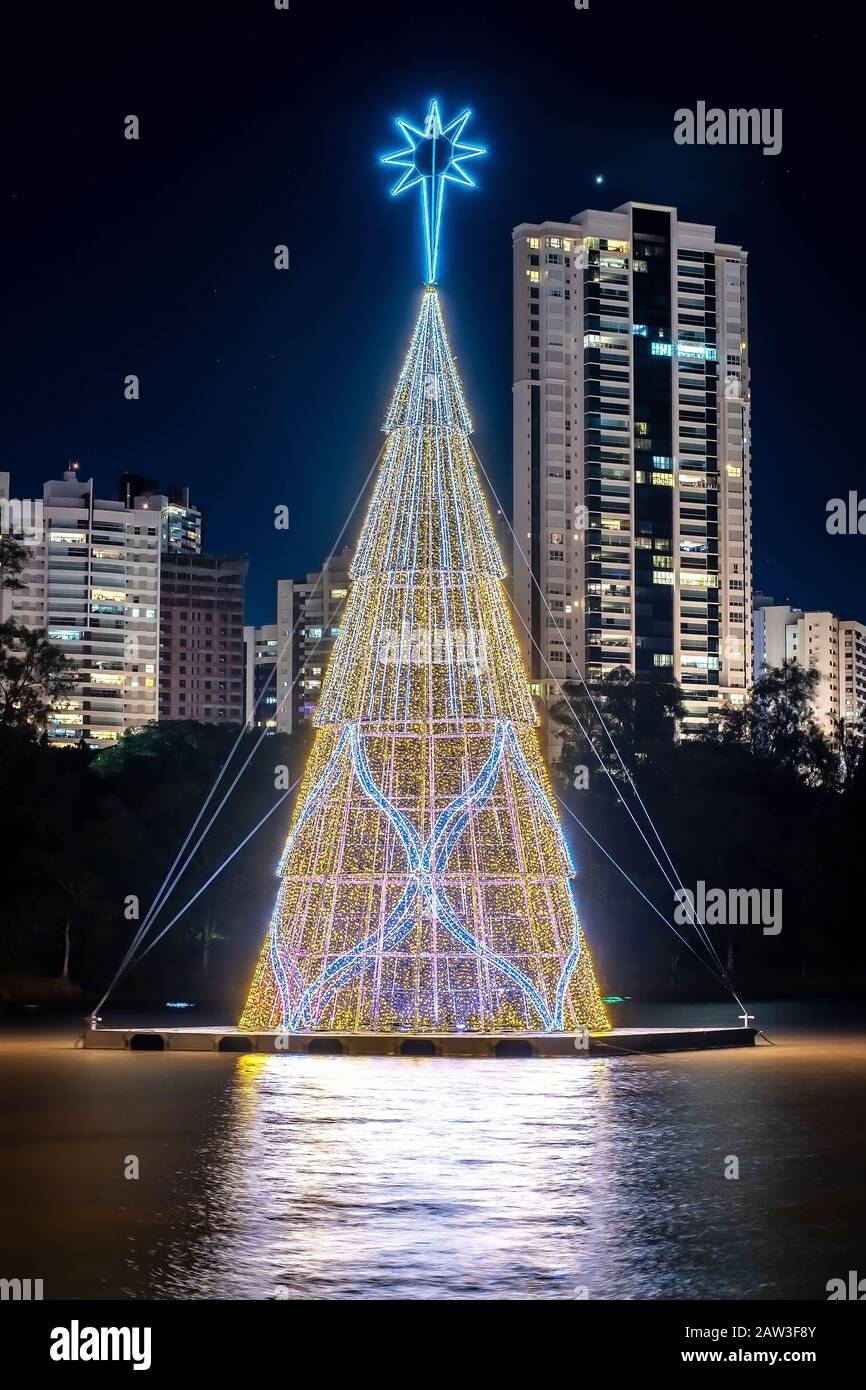 Christmas tree floating on the water of a lake and the buildings of the ...