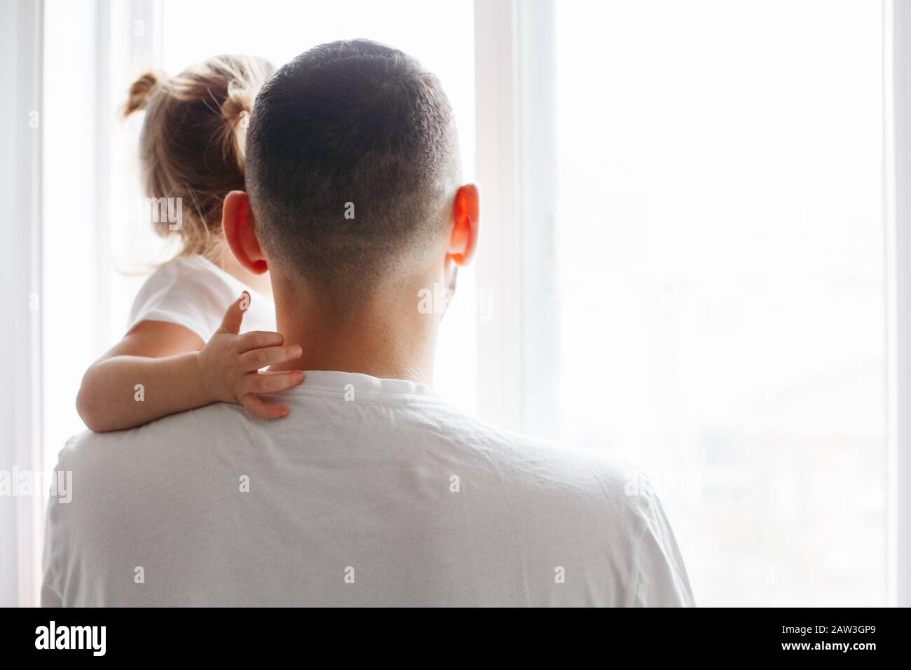 Father with toddler girl daughter looking into window waiting expecting ...