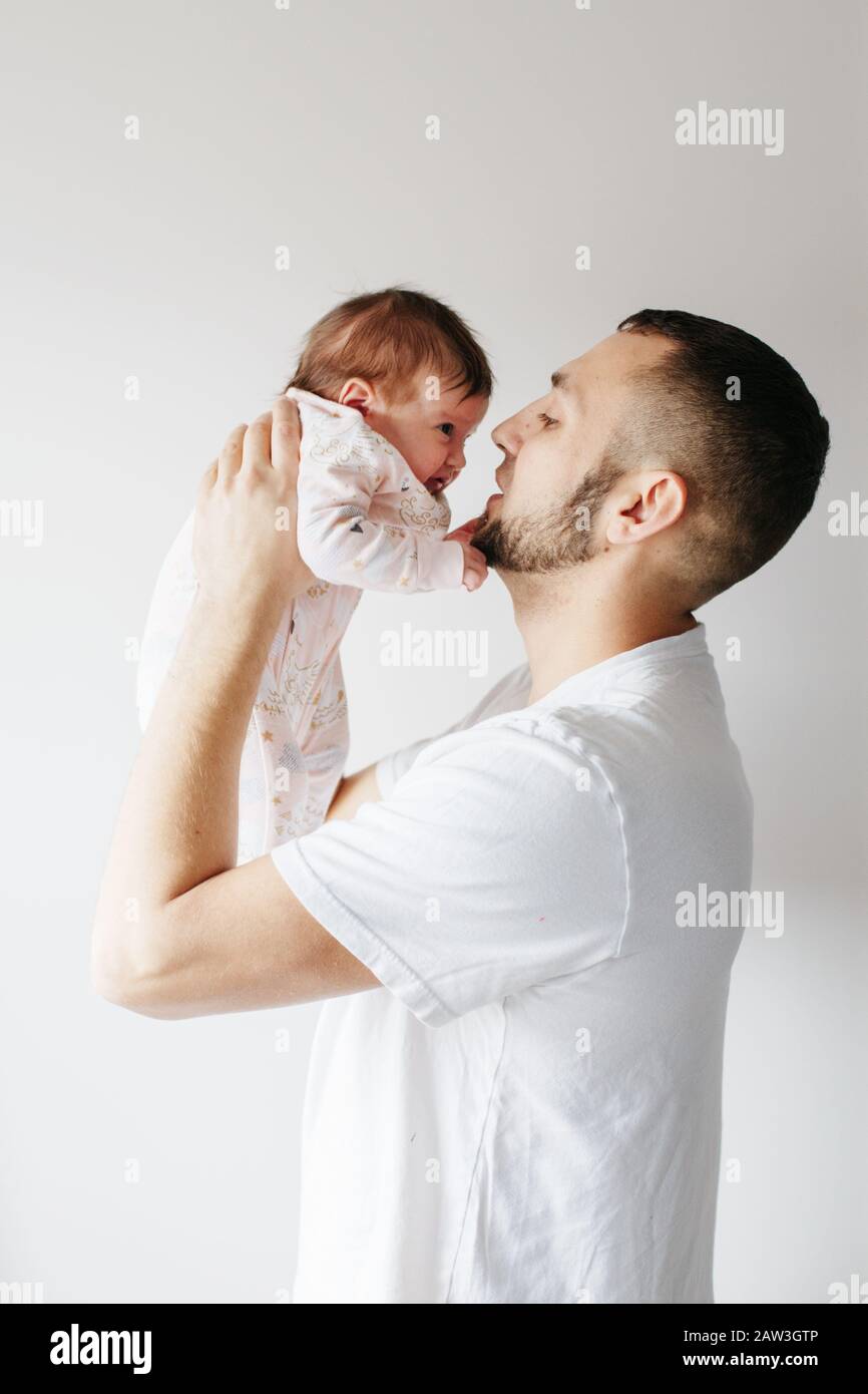 Young Caucasian father trying to calm down newborn baby. Male man ...