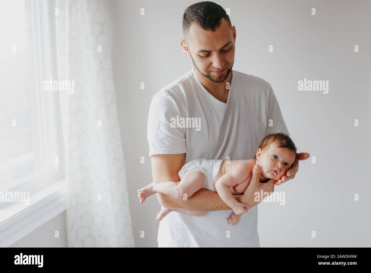 Happy Caucasian father holding newborn baby. Male bearded man parent ...