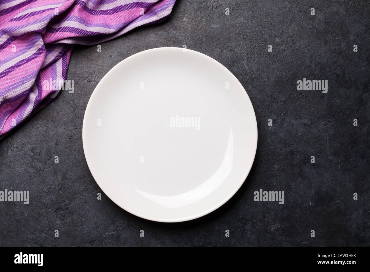 Kitchen table with empty plate, tablecloth and space for your recipe or ...
