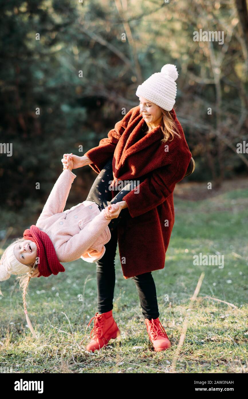 Mother and daughter have fun and frolic while walking in the forest ...