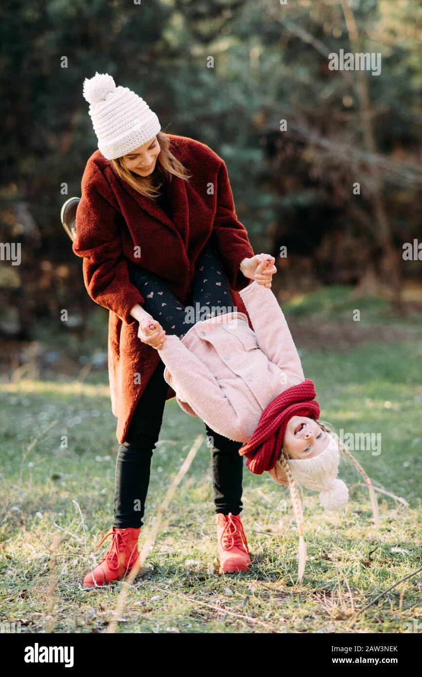 Mother and daughter have fun and frolic while walking in the forest ...