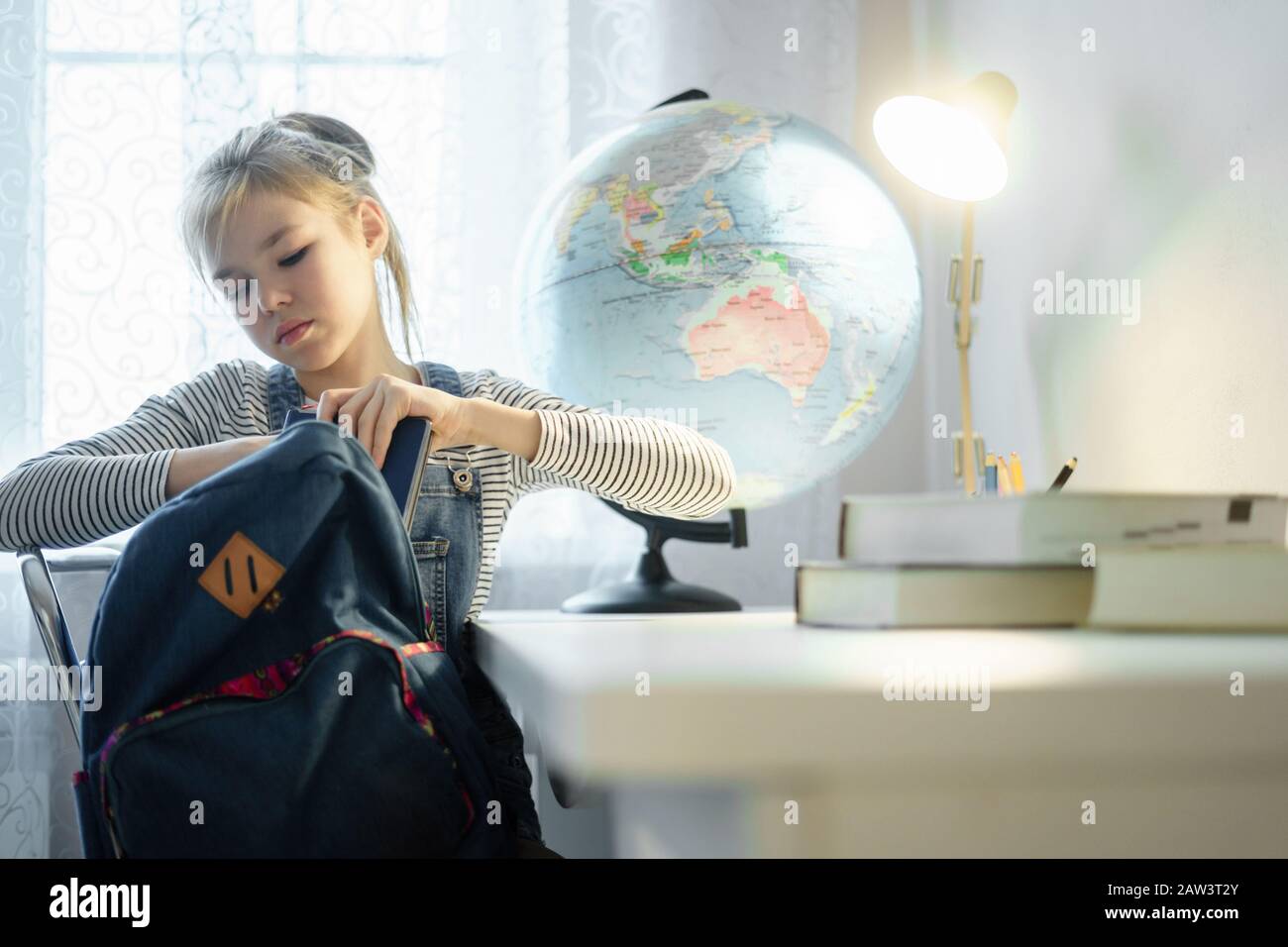 daughter packing stuff in backpack for school Stock Photo - Alamy