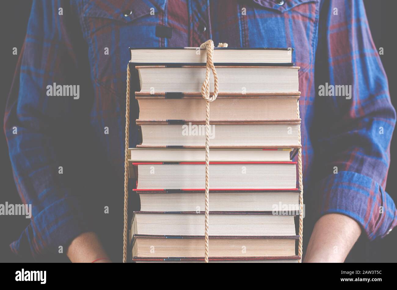 A man holds many books tied with a rope Stock Photo - Alamy