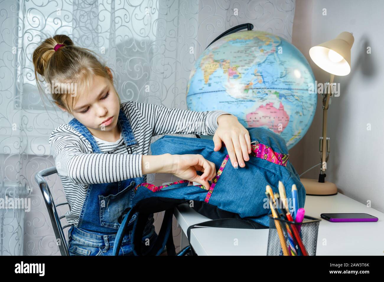 daughter packing stuff in backpack for school Stock Photo - Alamy