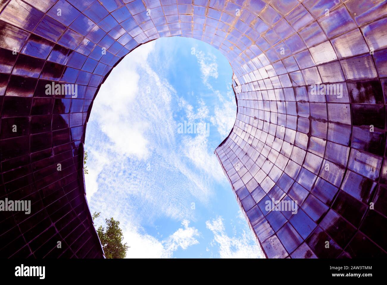 Conical smooth tile surface pointing to the blue sky with reflections ...