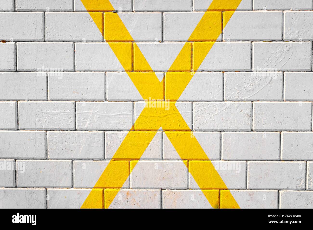 Large X shaped yellow cross painted on the pavement, background of a ...