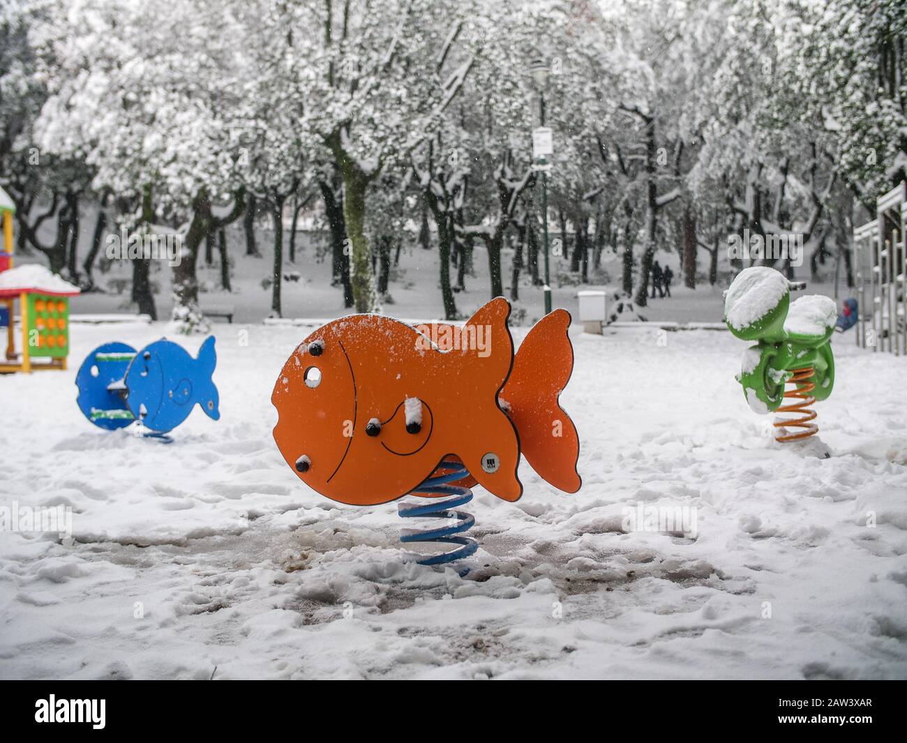 Spring ride covered in snow in deserted kids playground. Shape of fish ...