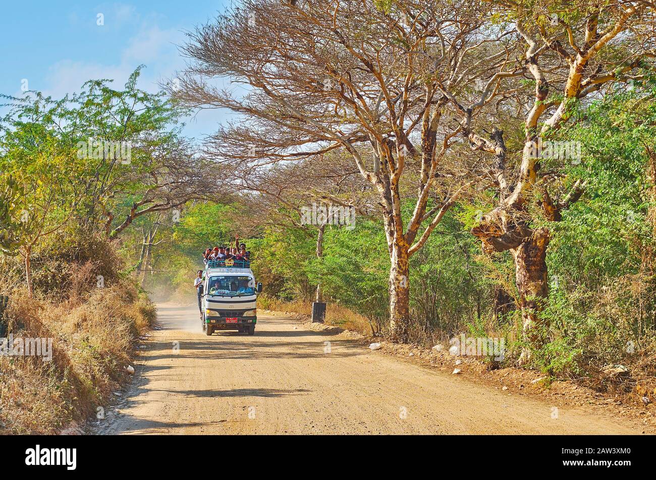 BAGAN, MYANMAR - FEBRUARY 25, 2018: The truck, full of people drives ...