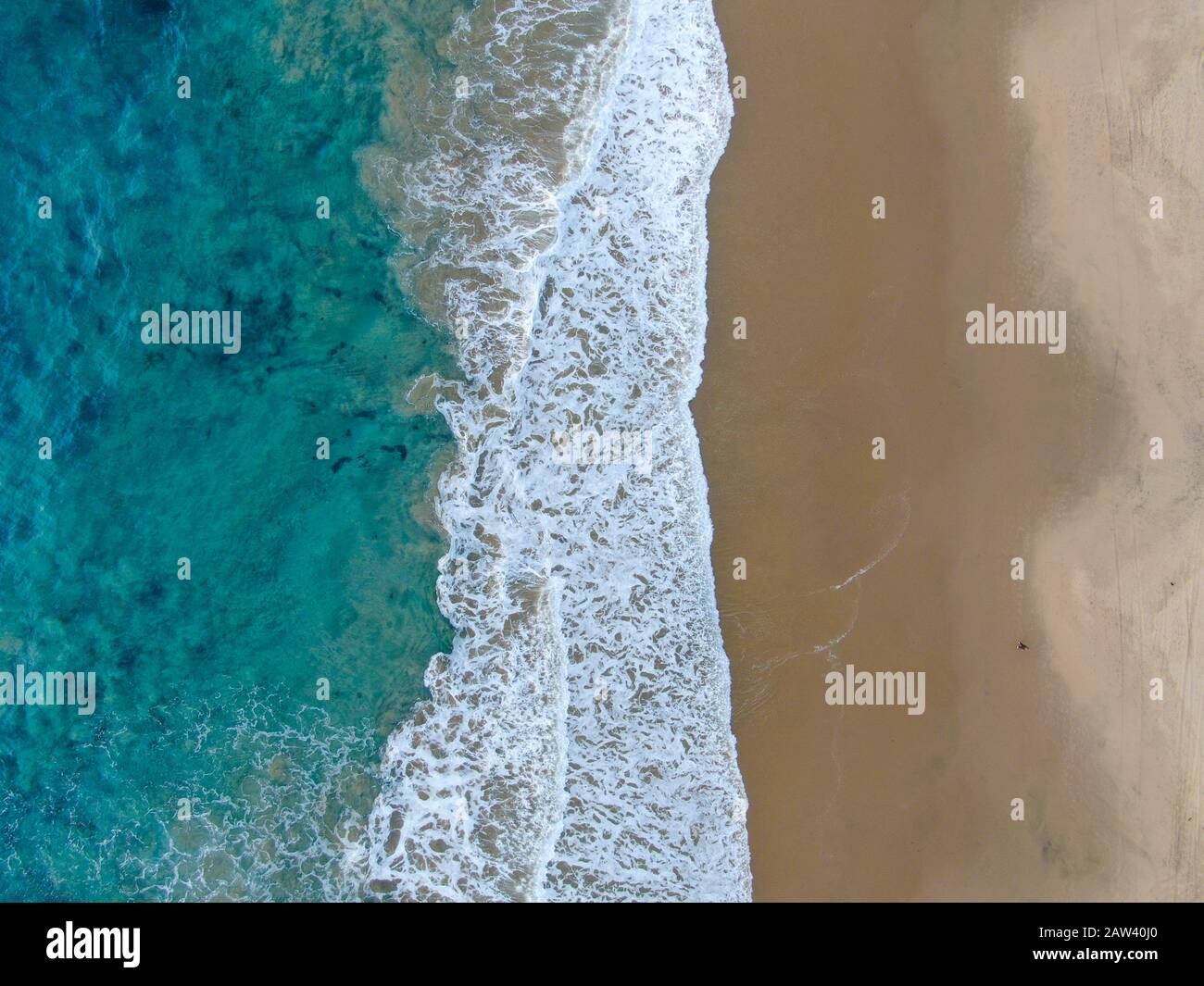 Aerial top view of the ocean colorful waves washing on the coast of the ...