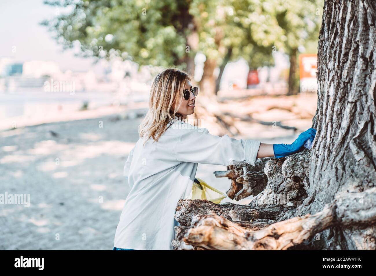 Girl picking up trash from the park. She collecting the litter in ...