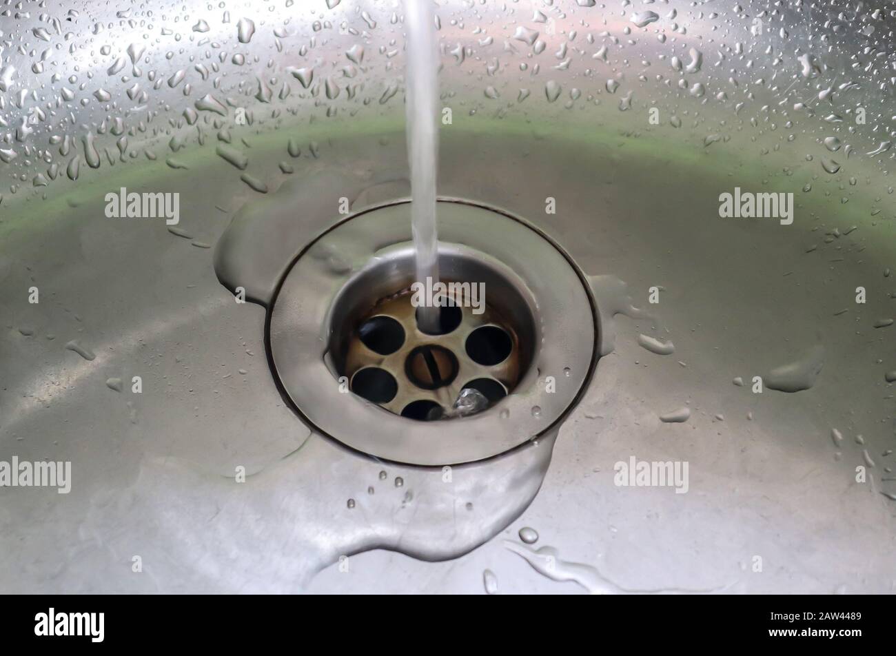 Running water out of a water tap in a metallic kitchen sink Stock Photo ...