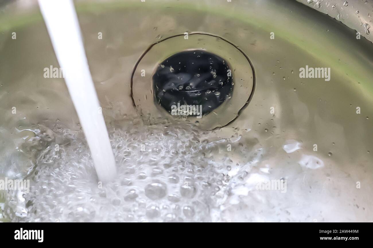 Running water out of a water tap in a metallic kitchen sink Stock Photo ...
