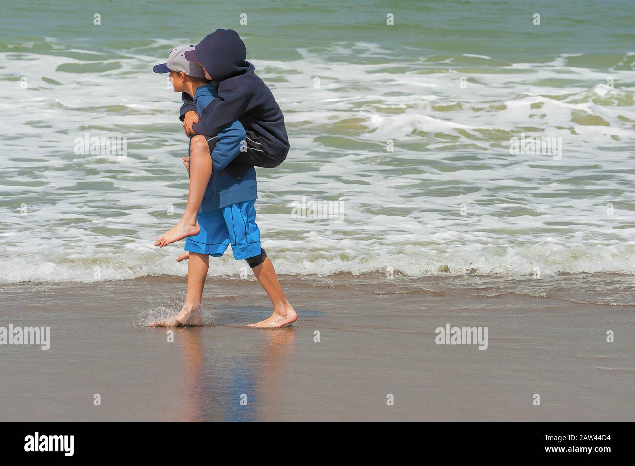 Two brothers playing piggyback at water's edge in Lincoln City on the ...