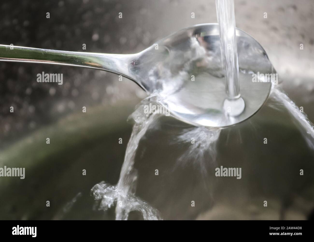 Running water out of a water tap in a metallic kitchen sink Stock Photo ...