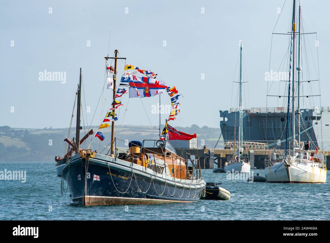 Older style RNLI lifeboat in bright sunshine at anchor dressed overall ...
