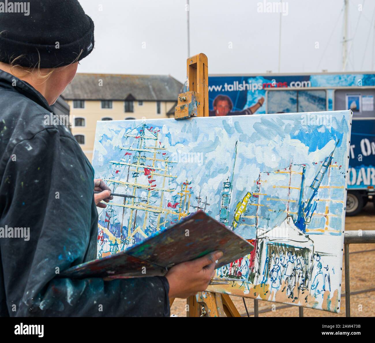 lady artist painting on an easel in the open air of a twin masted ship ...