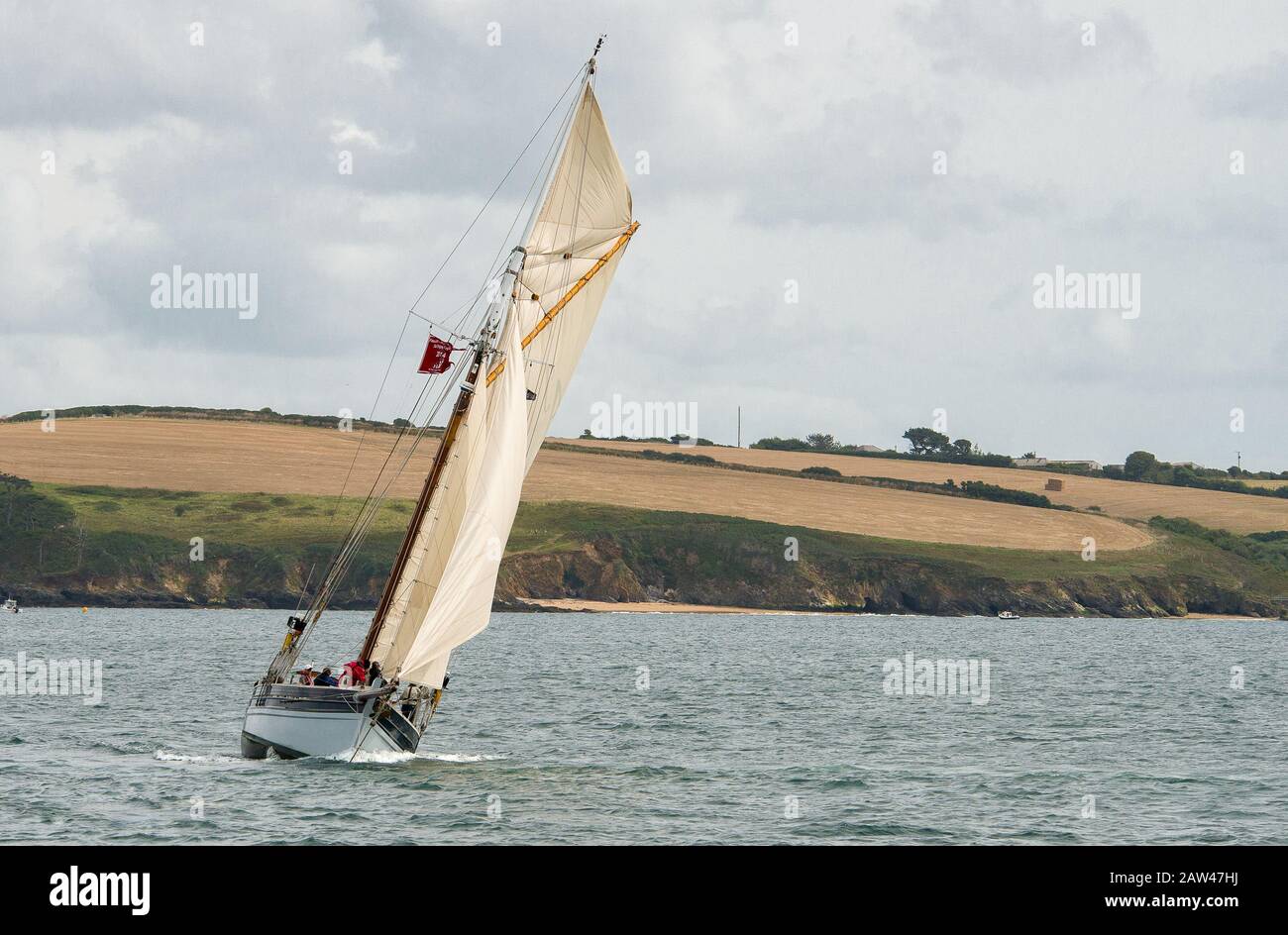 Small yacht sailing in the open waters of the Fal, heeled over by the ...