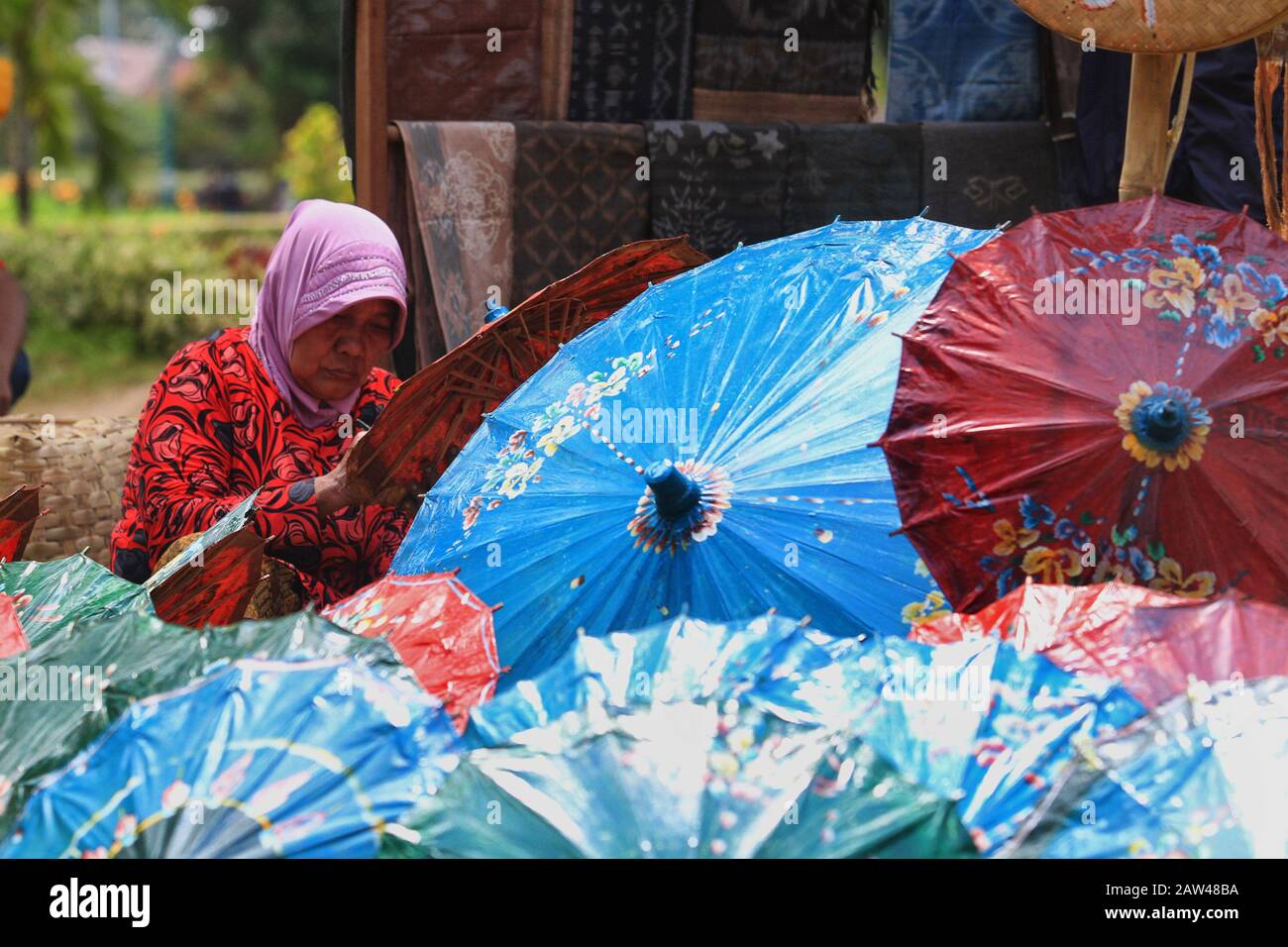 Indonesian woman paints an umbrella that will be exhibited during the ...