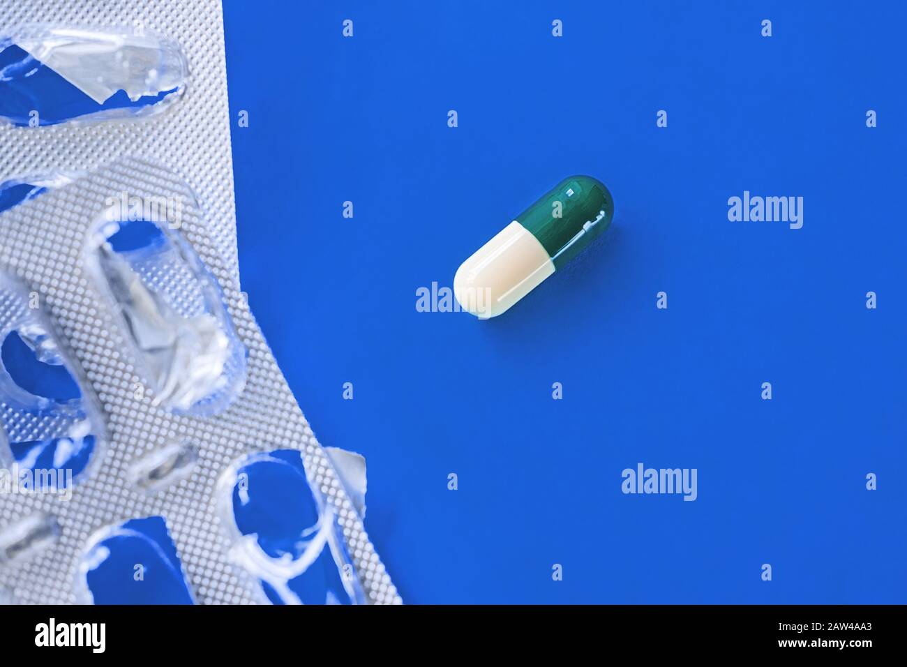 On a classic blue background, a medicine capsule. Several empty ...