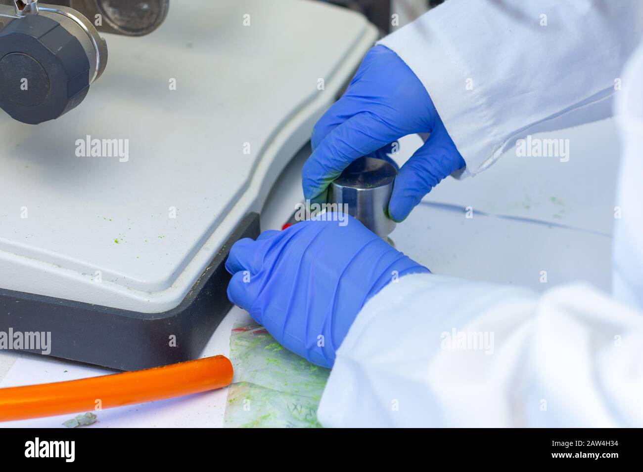 Preparation of sample using vibrating mill. Woman hands in blue gloves ...